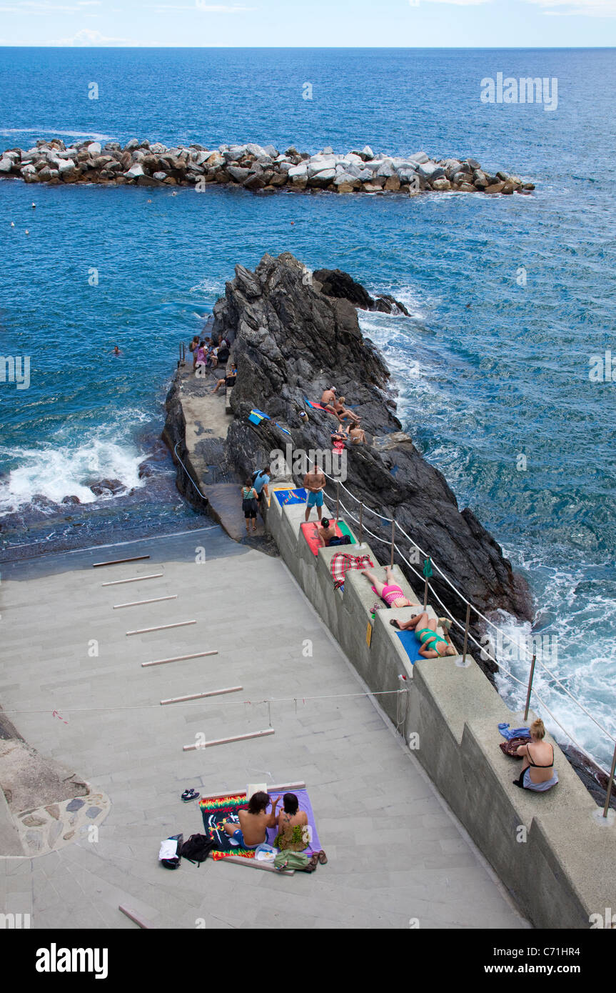 People sunbathing on slipway at Manarola, National park Cinque Terre ...