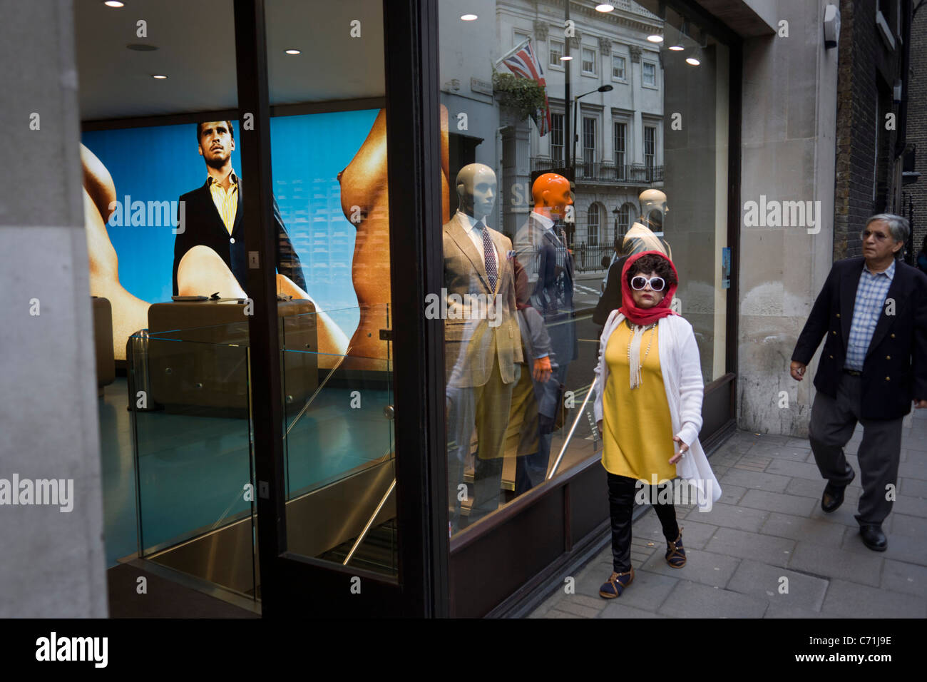 Eccentric looking woman passes-by Suitsupply, a fashion shop on Vigo ...