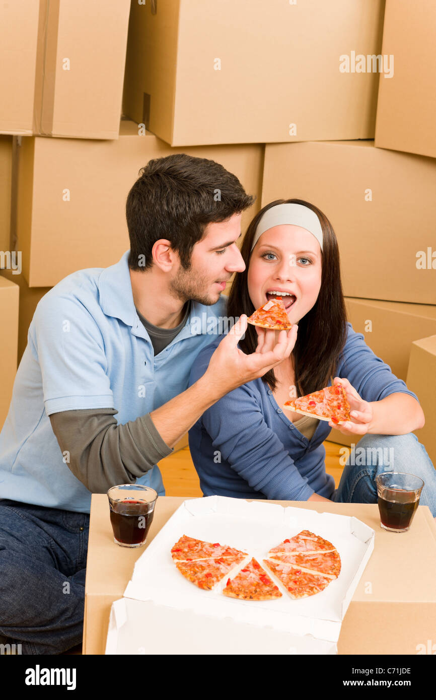 Moving into new home young happy couple eating pizza Stock Photo - Alamy