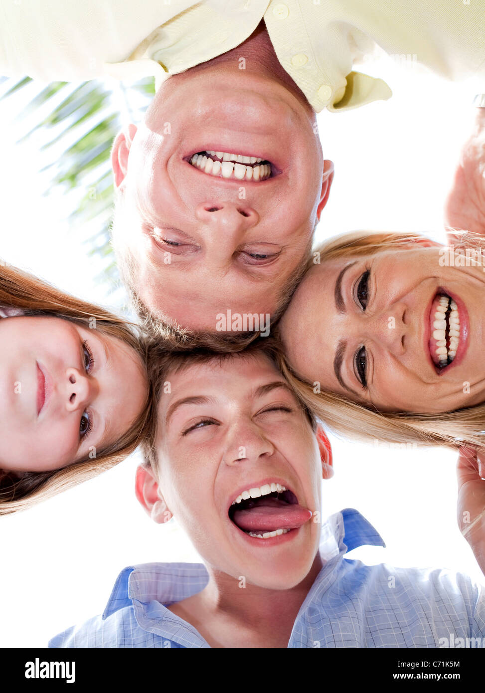 Happy family joining their heads together and mocking fun towards the ...