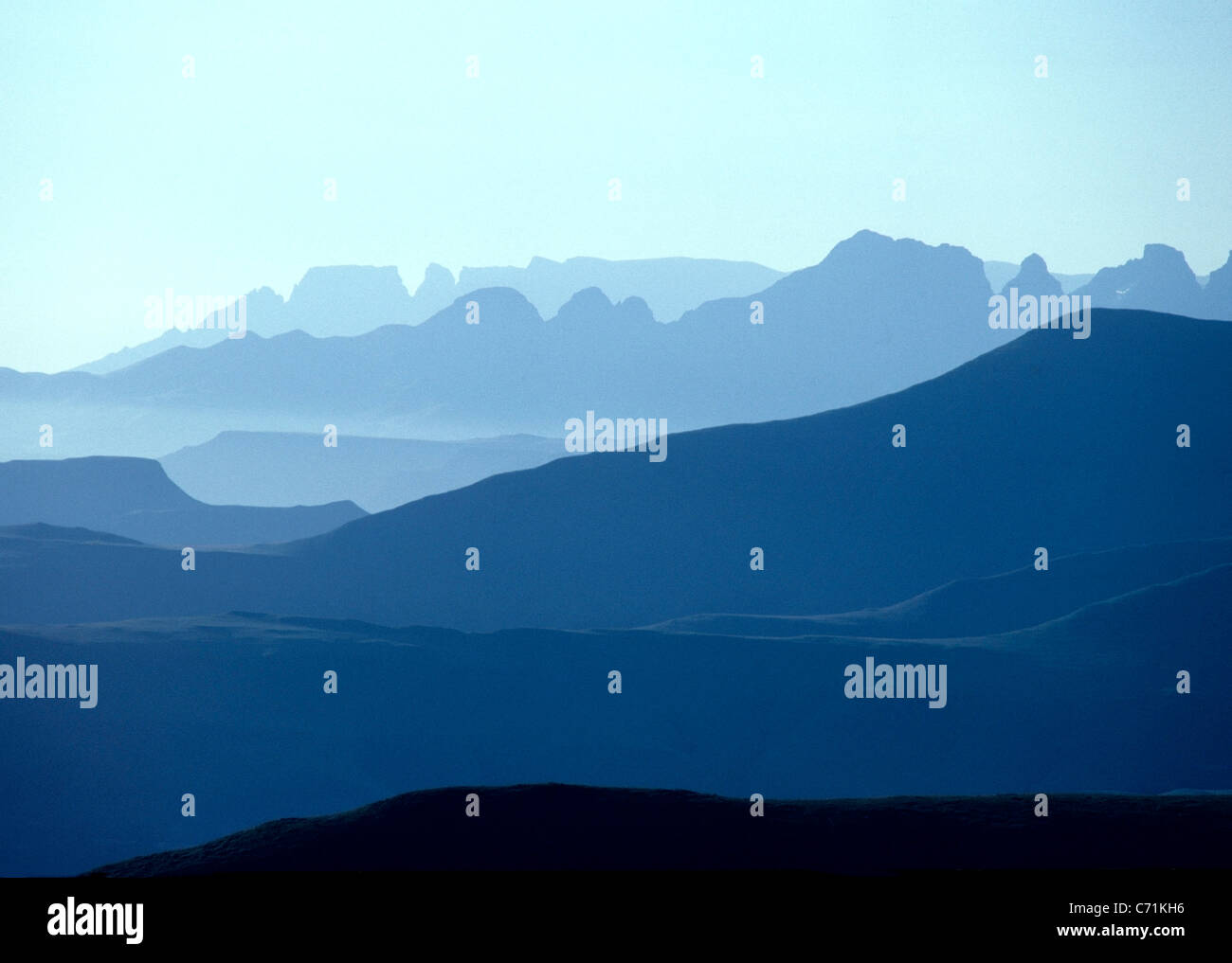 Morning mist over the Drakensberg ranges towards the Devils's Tooth and ...