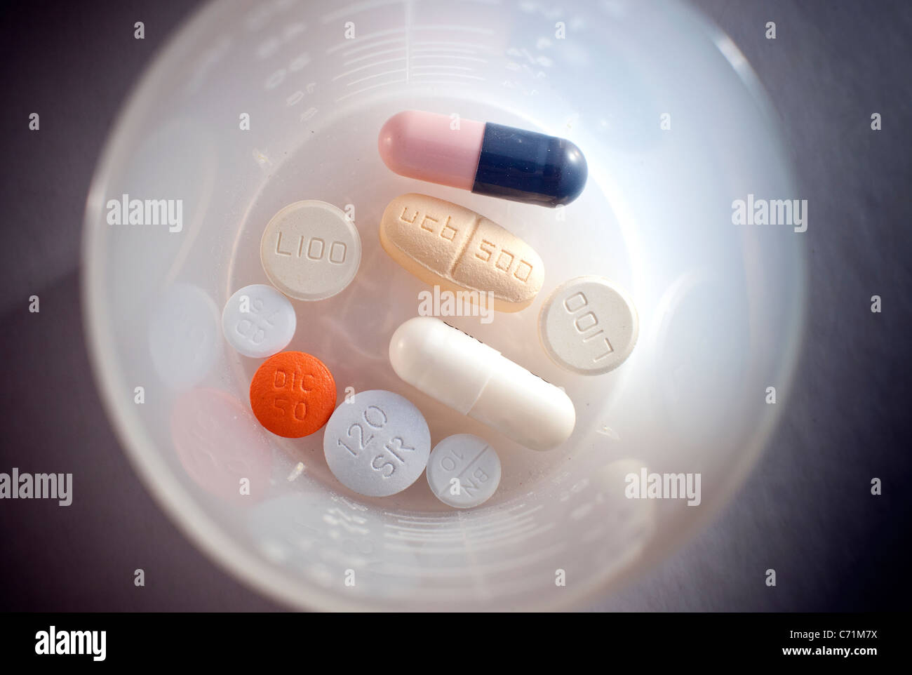 A dose of medication tablets in a plastic beaker Stock Photo - Alamy