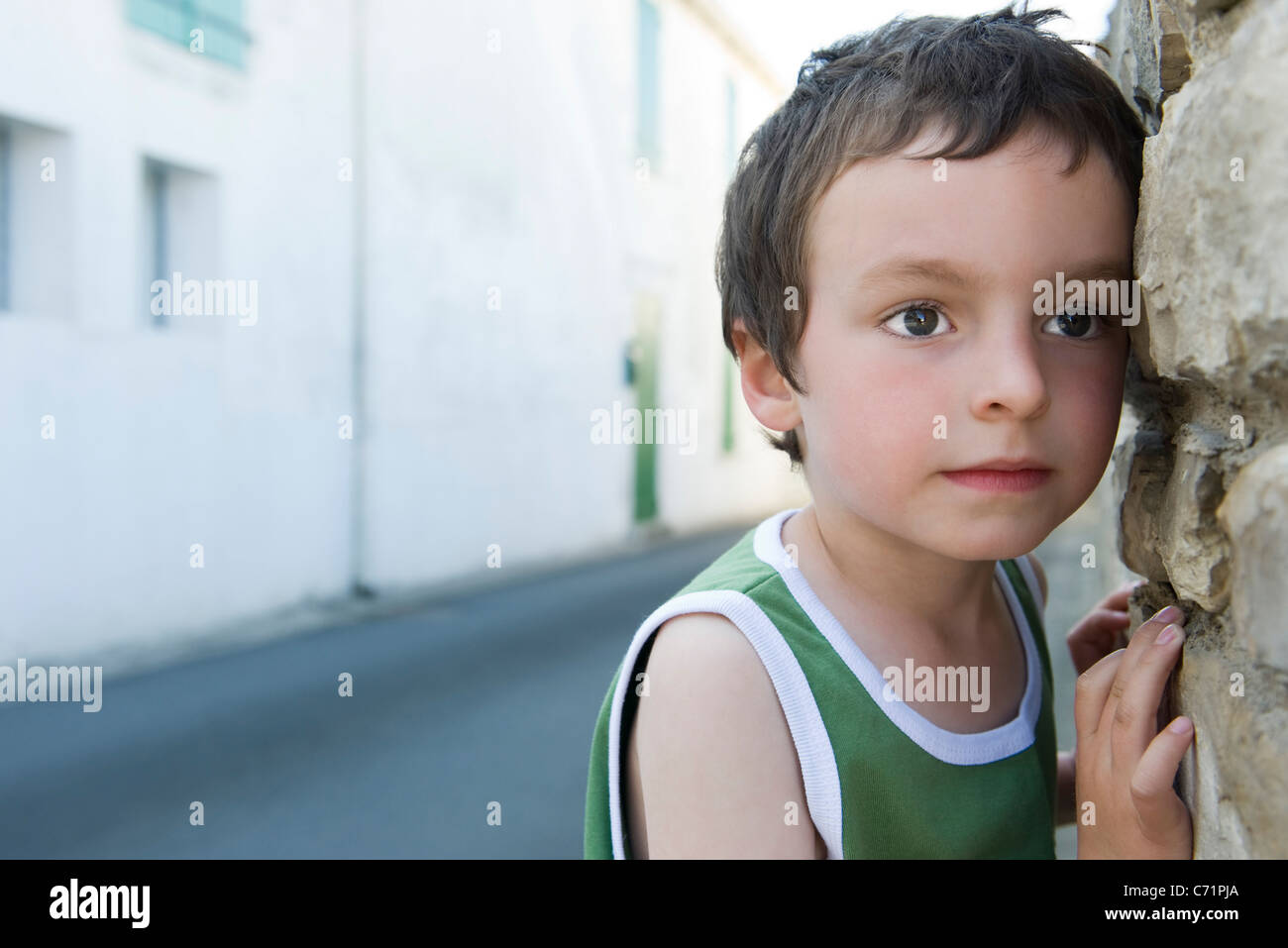 Little boy leaning against wall, portrait Stock Photo - Alamy