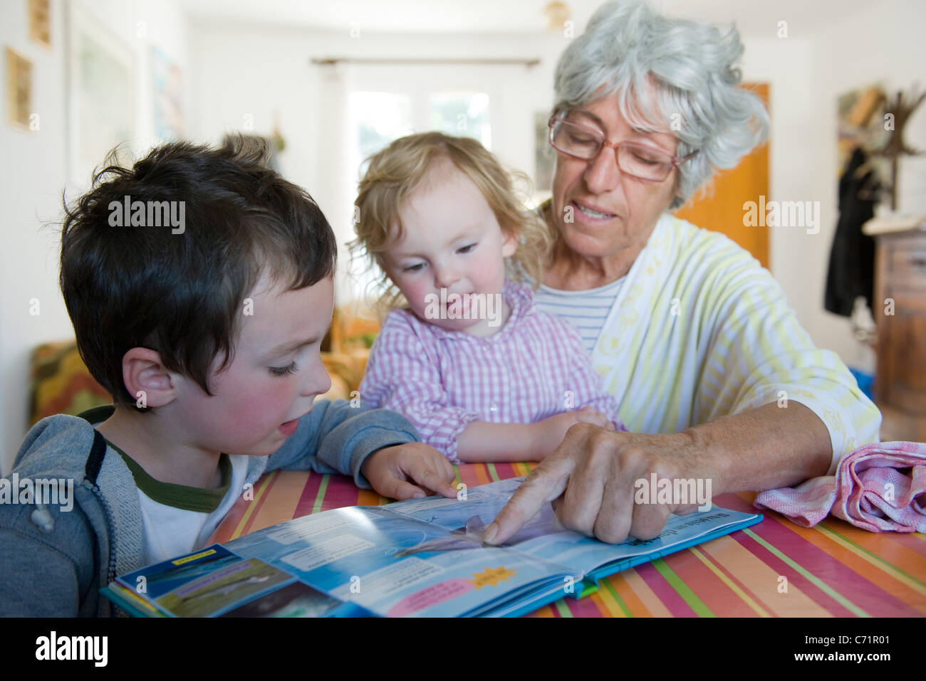 Grandmother reading book with young grandchildren Stock Photo - Alamy
