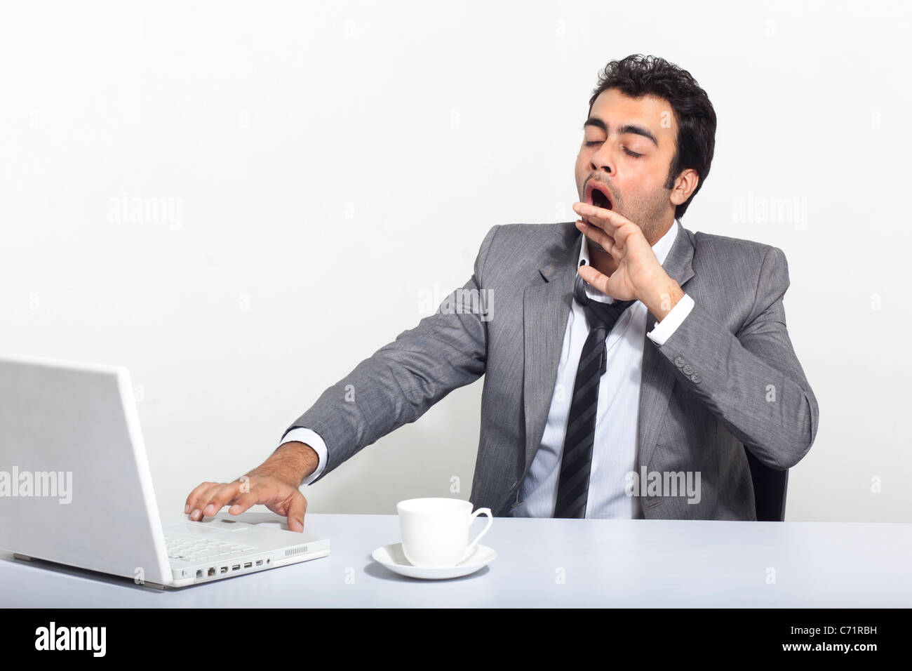 Businessman yawning at work Stock Photo - Alamy