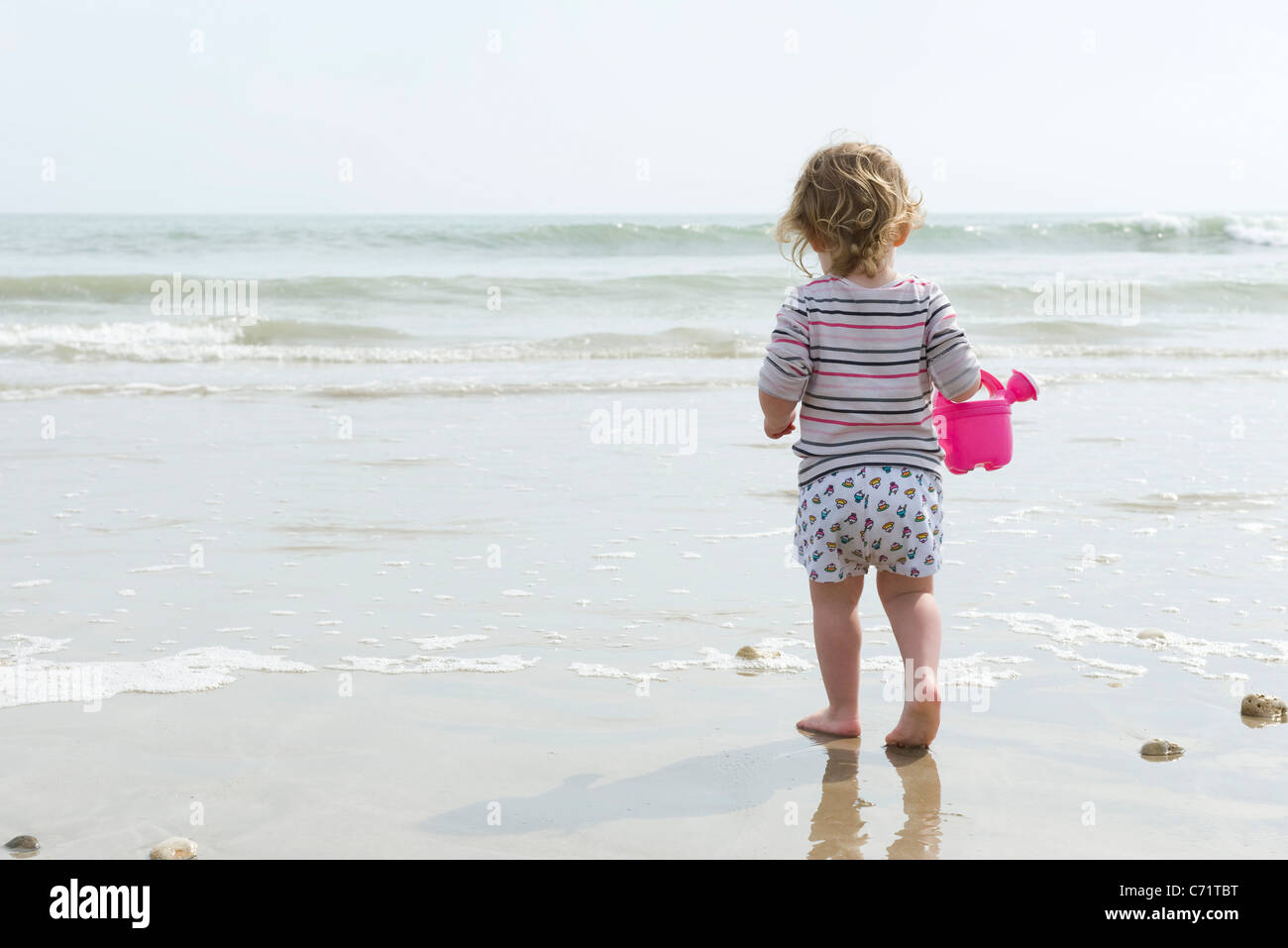 Toddler girl walking at the beach, rear view Stock Photo - Alamy