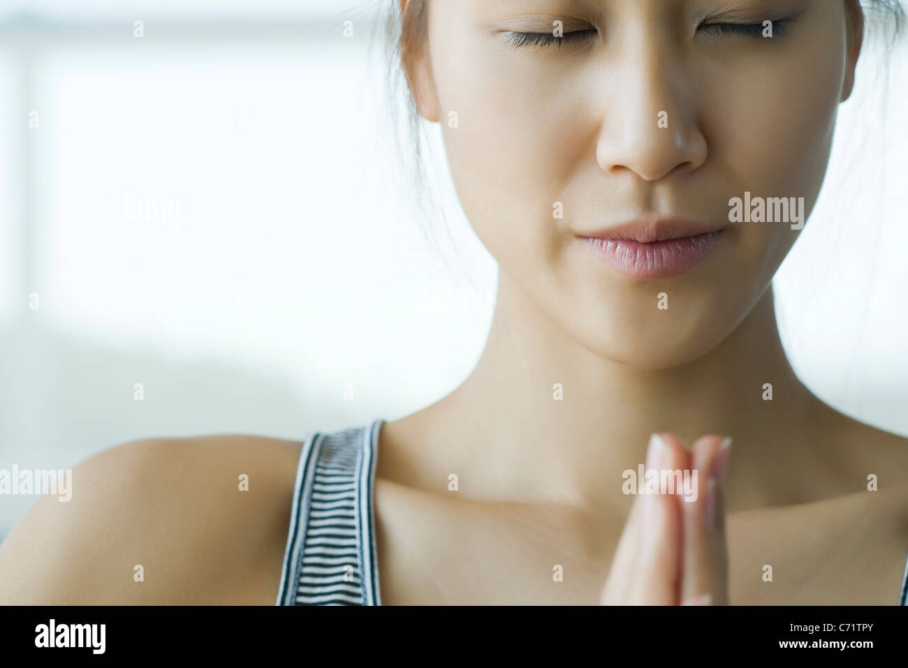 Young woman meditating in prayer position Stock Photo - Alamy