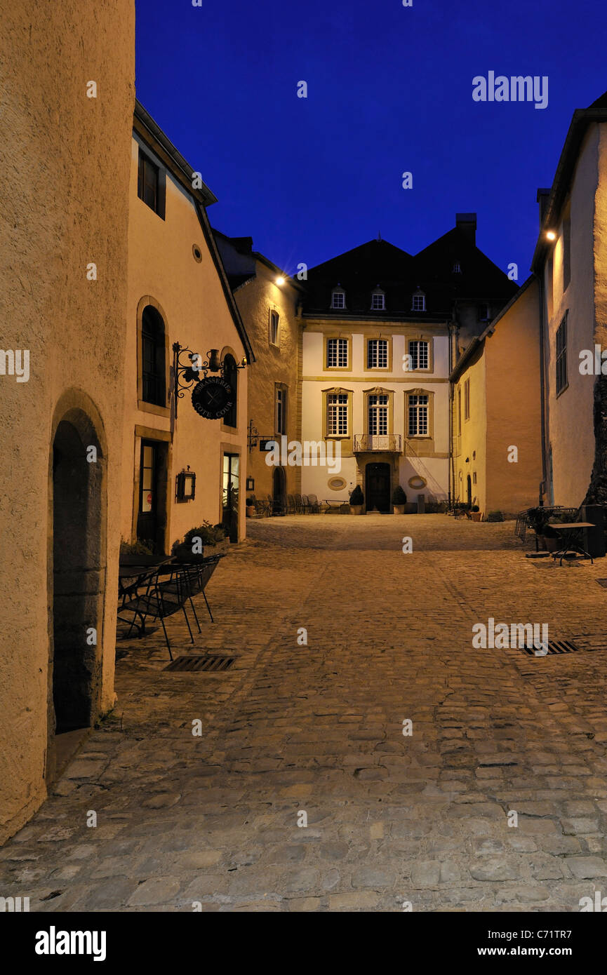 Cobbled inner court inside the Bourglinster Castle illuminated at night ...