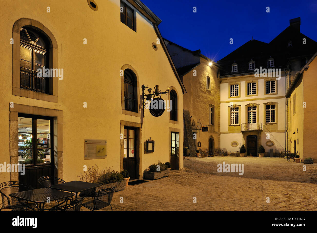 Cobbled inner court inside the Bourglinster Castle illuminated at night ...