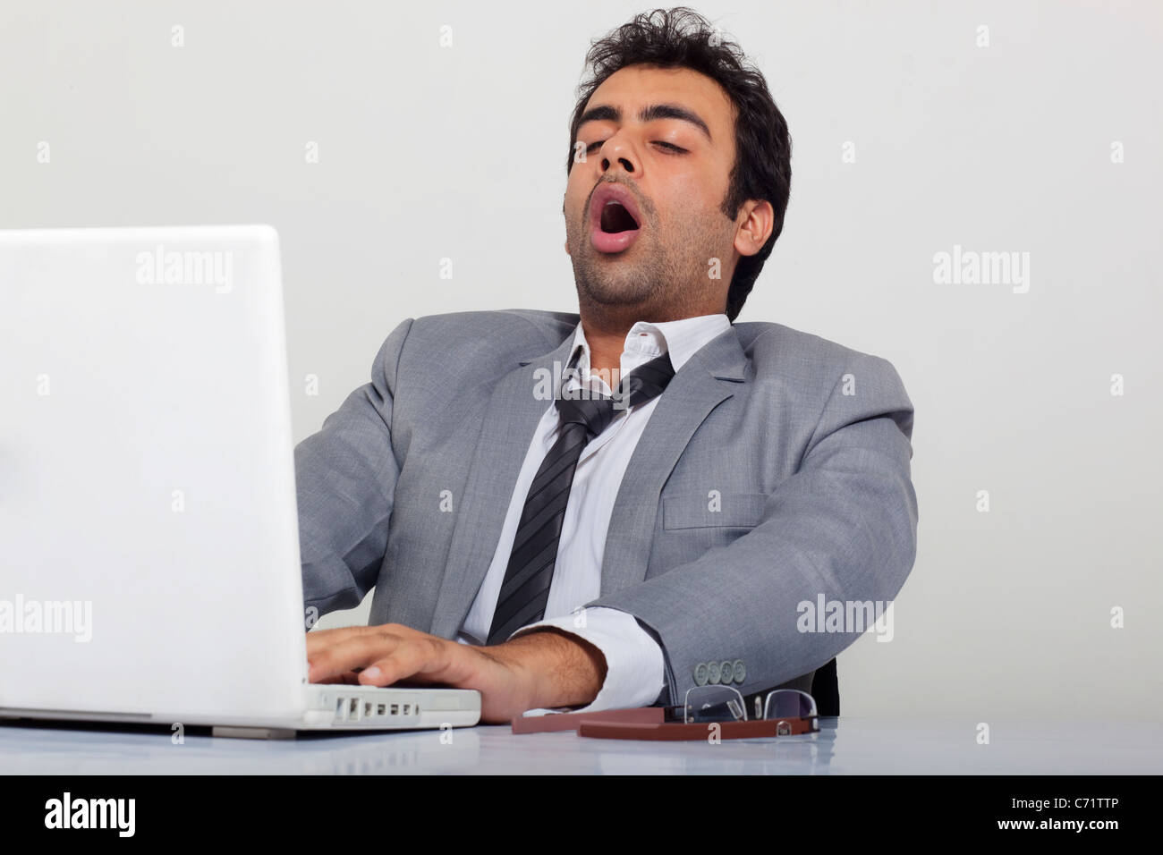 Businessman yawning at work Stock Photo - Alamy