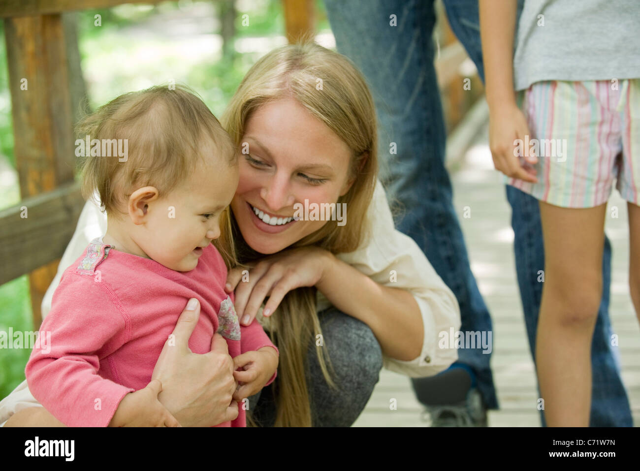 Mother crouching beside baby outdoors Stock Photo - Alamy