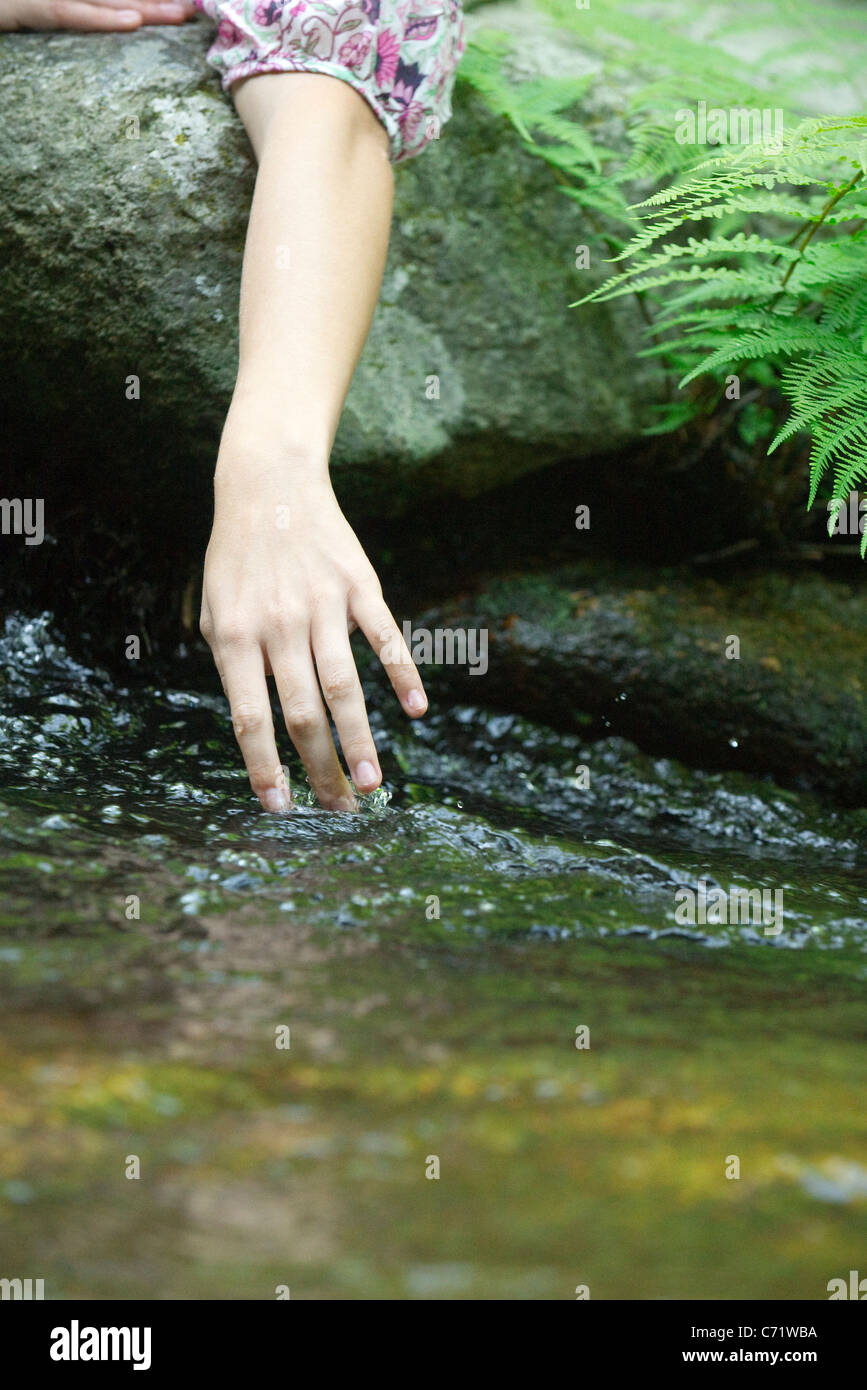 Young woman's hand touching water in stream Stock Photo - Alamy