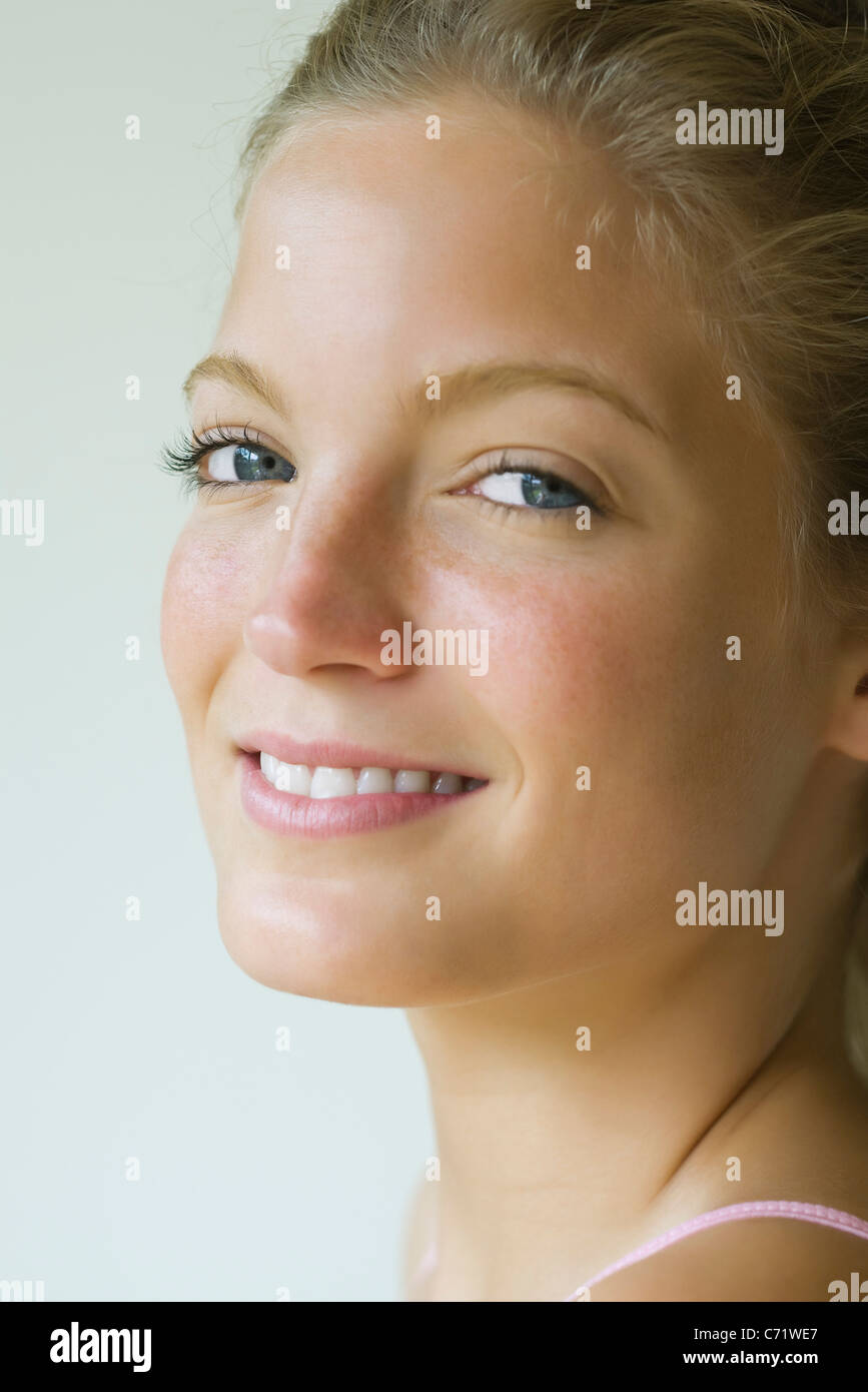 Young woman glancing over shoulder at camera, portrait Stock Photo - Alamy