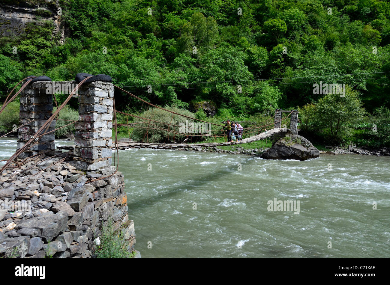 A primitive hanging bridge across a treacherous river. Sichuan, China ...