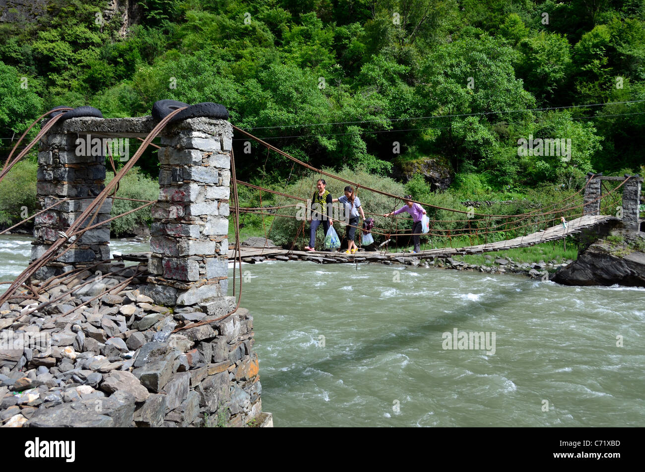A primitive hanging bridge across treacherous river. Sichuan, China ...