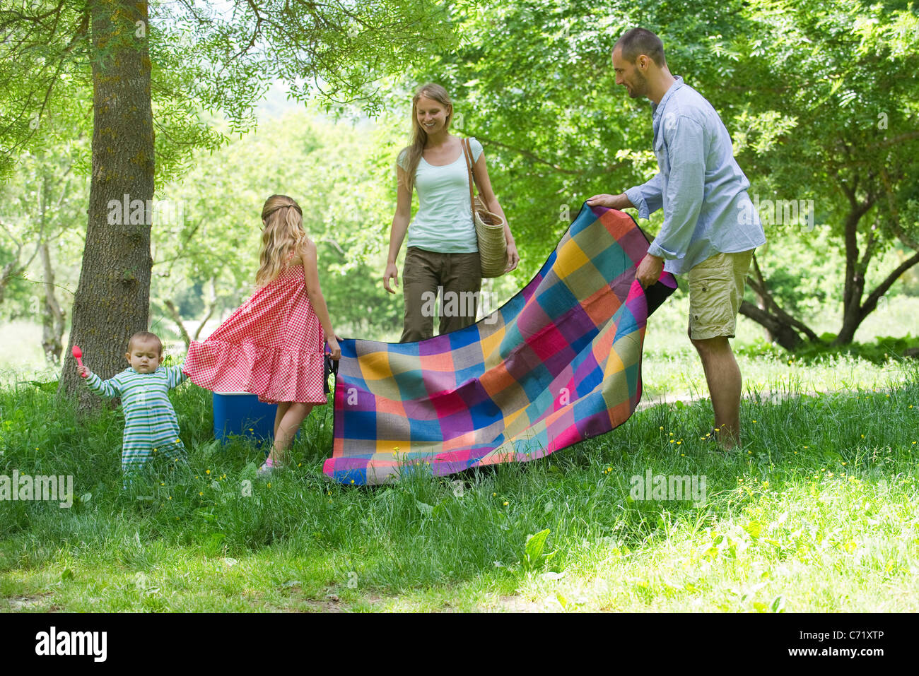 Family preparing for picnic in meadow Stock Photo - Alamy