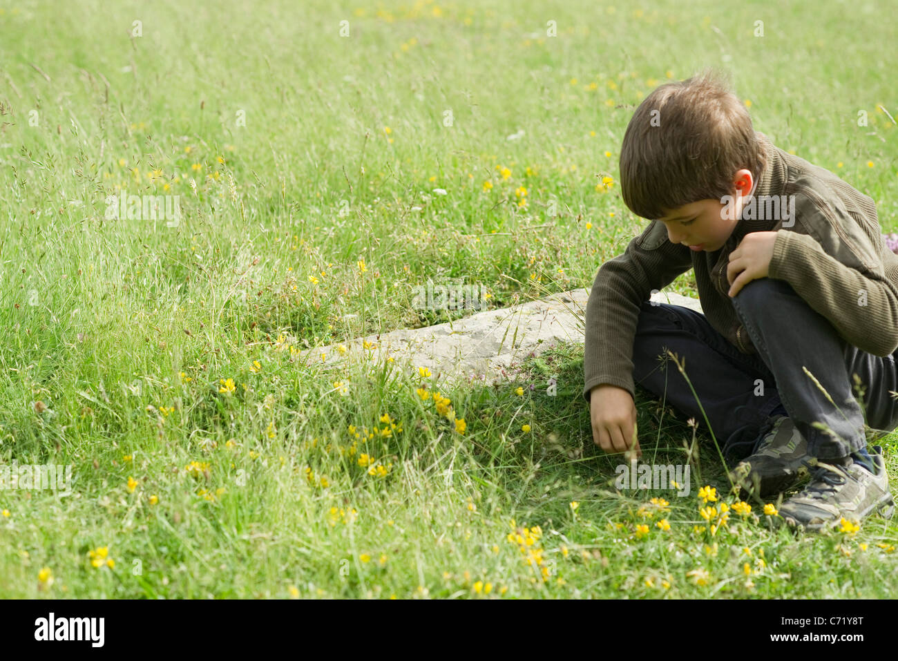 Boy looking at something on ground hi-res stock photography and images ...