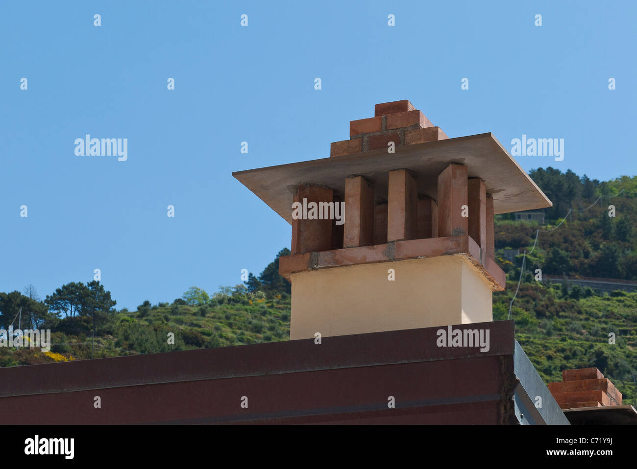A detail of the top of an Italian chimney made of masonry and ceramic ...