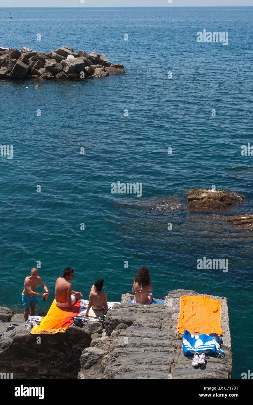 Young Italian adults sunbath and prepare to swim in the harbor of ...