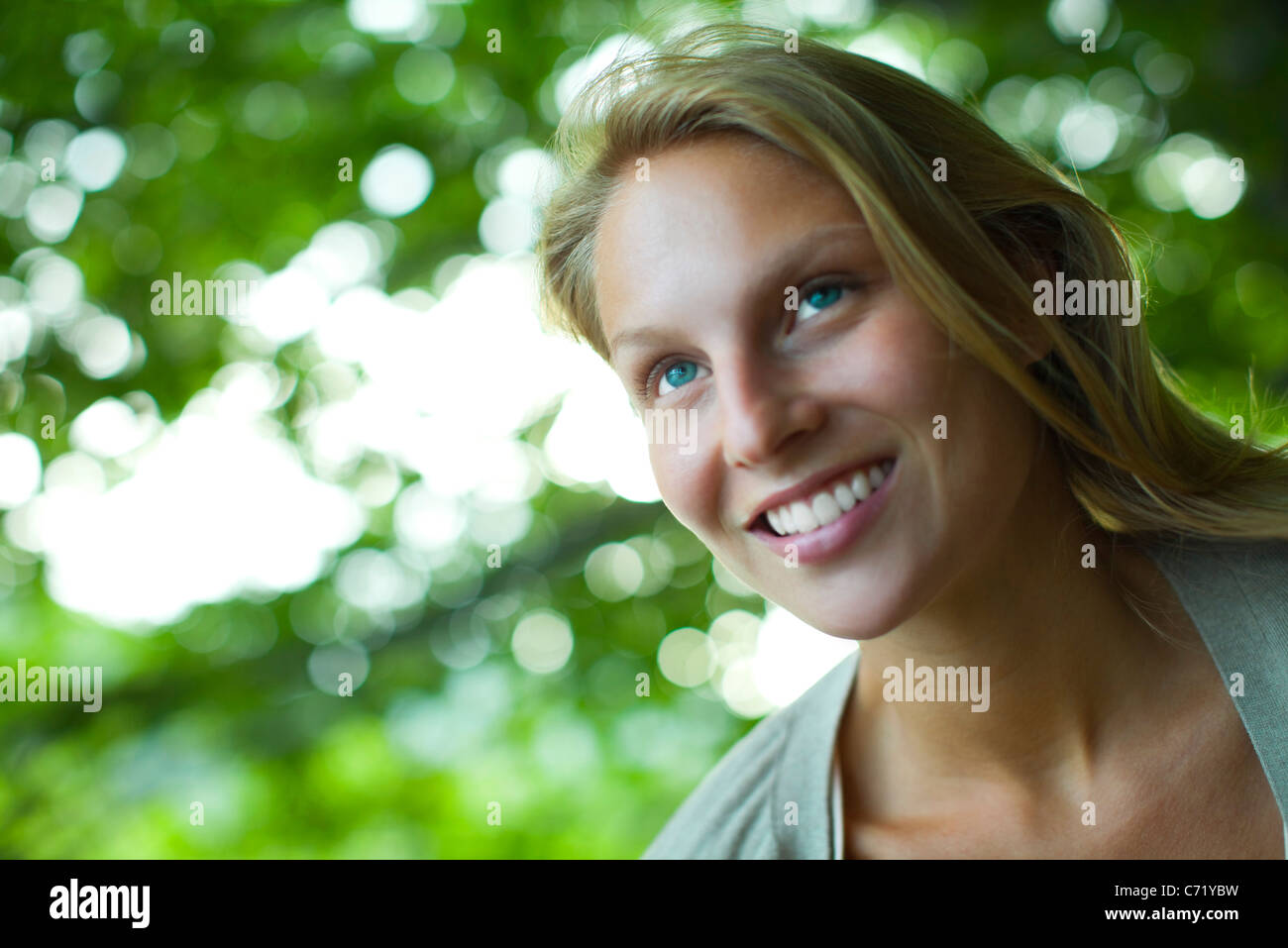 Young woman smiling, looking up, portrait Stock Photo - Alamy