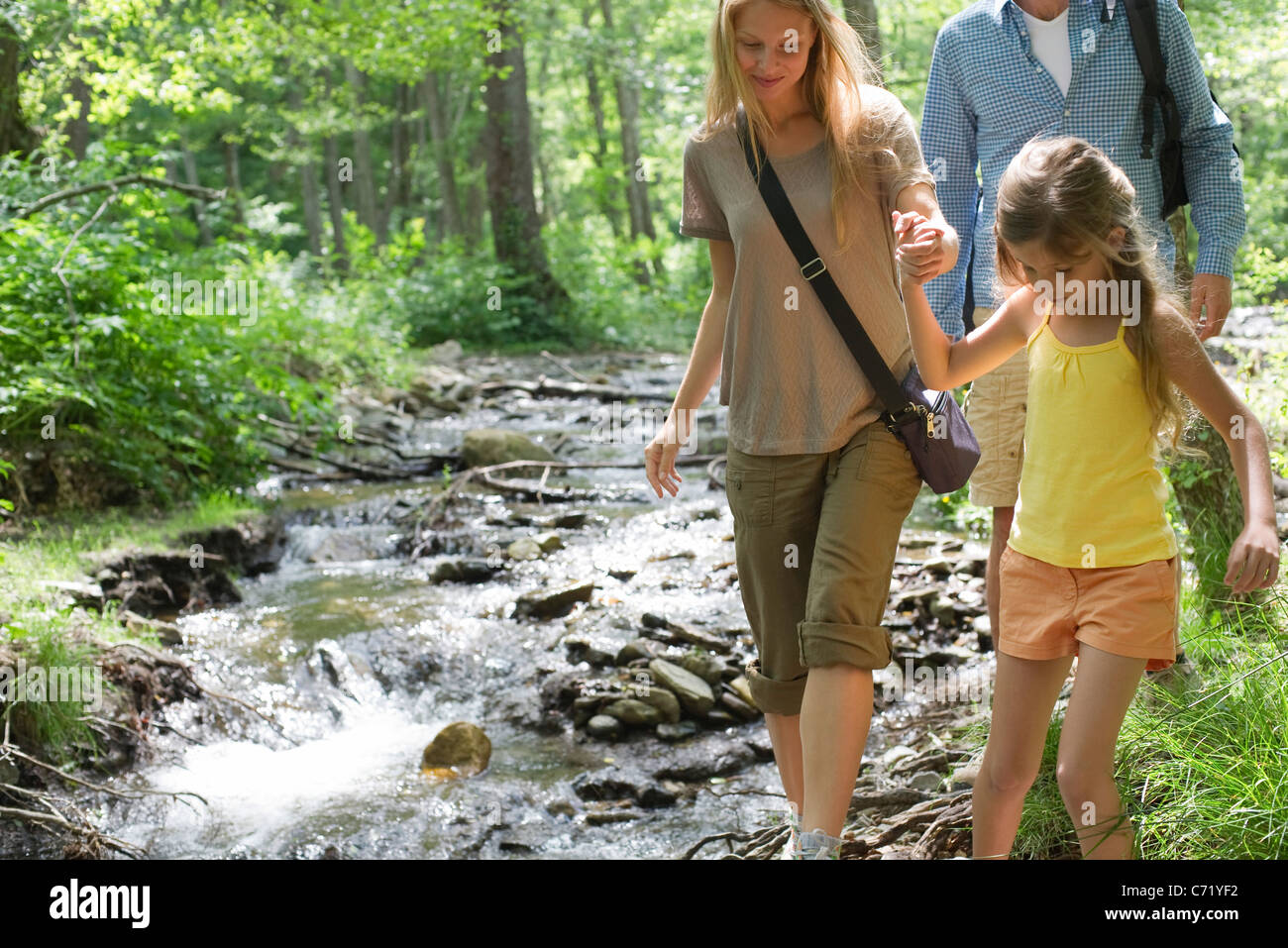 Family walking beside stream in woods Stock Photo - Alamy
