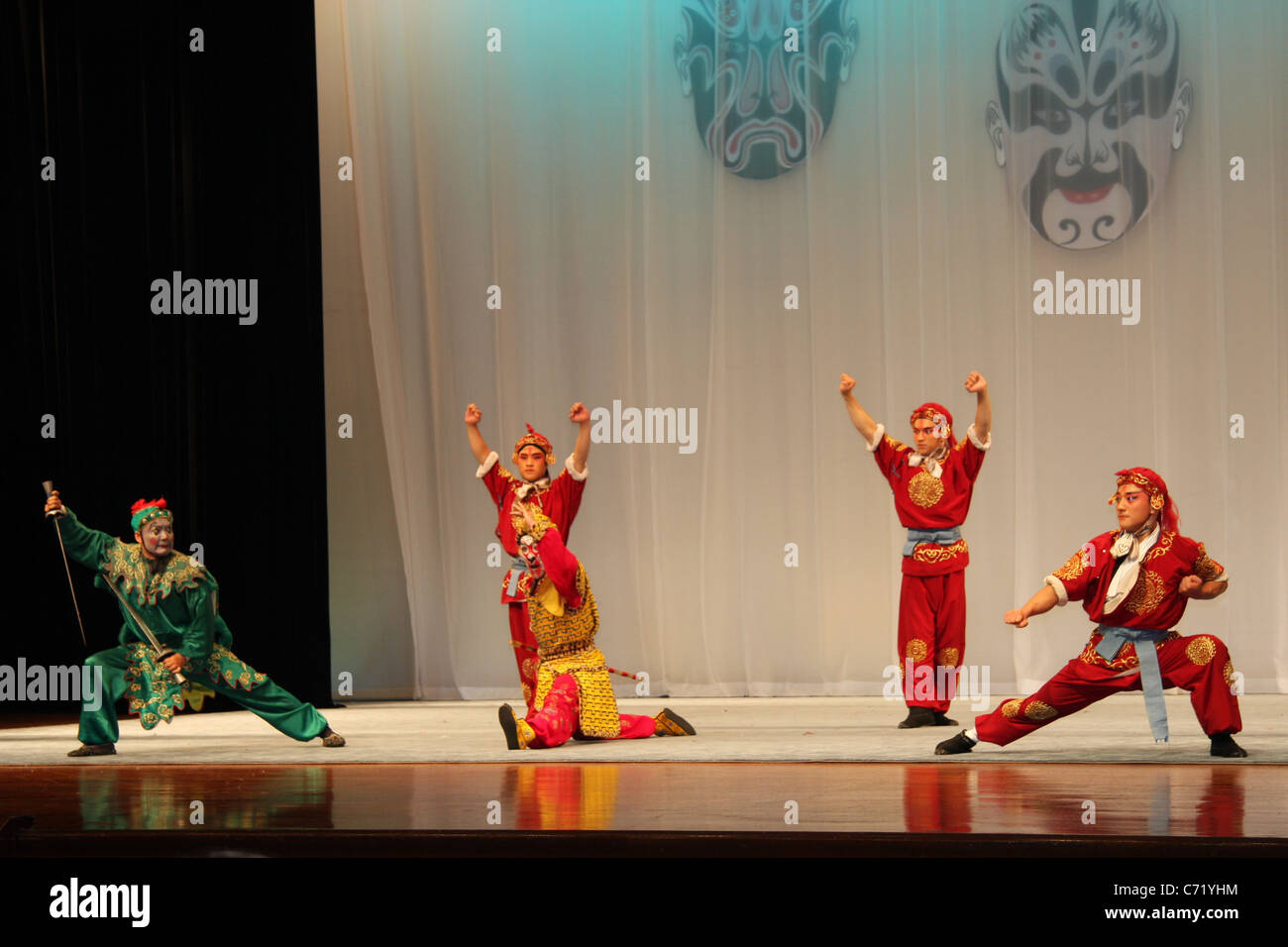Five men in colourful traditional costumes acting on stage at the ...