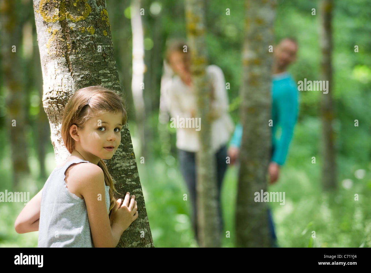 Girl hiding behind tree Stock Photo - Alamy