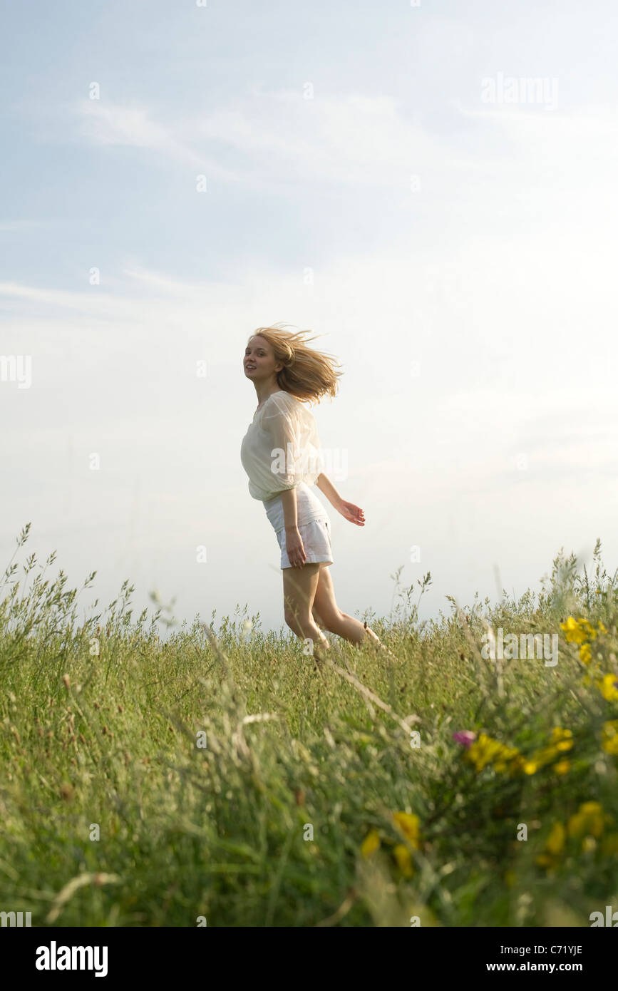 Young woman running through meadow Stock Photo - Alamy