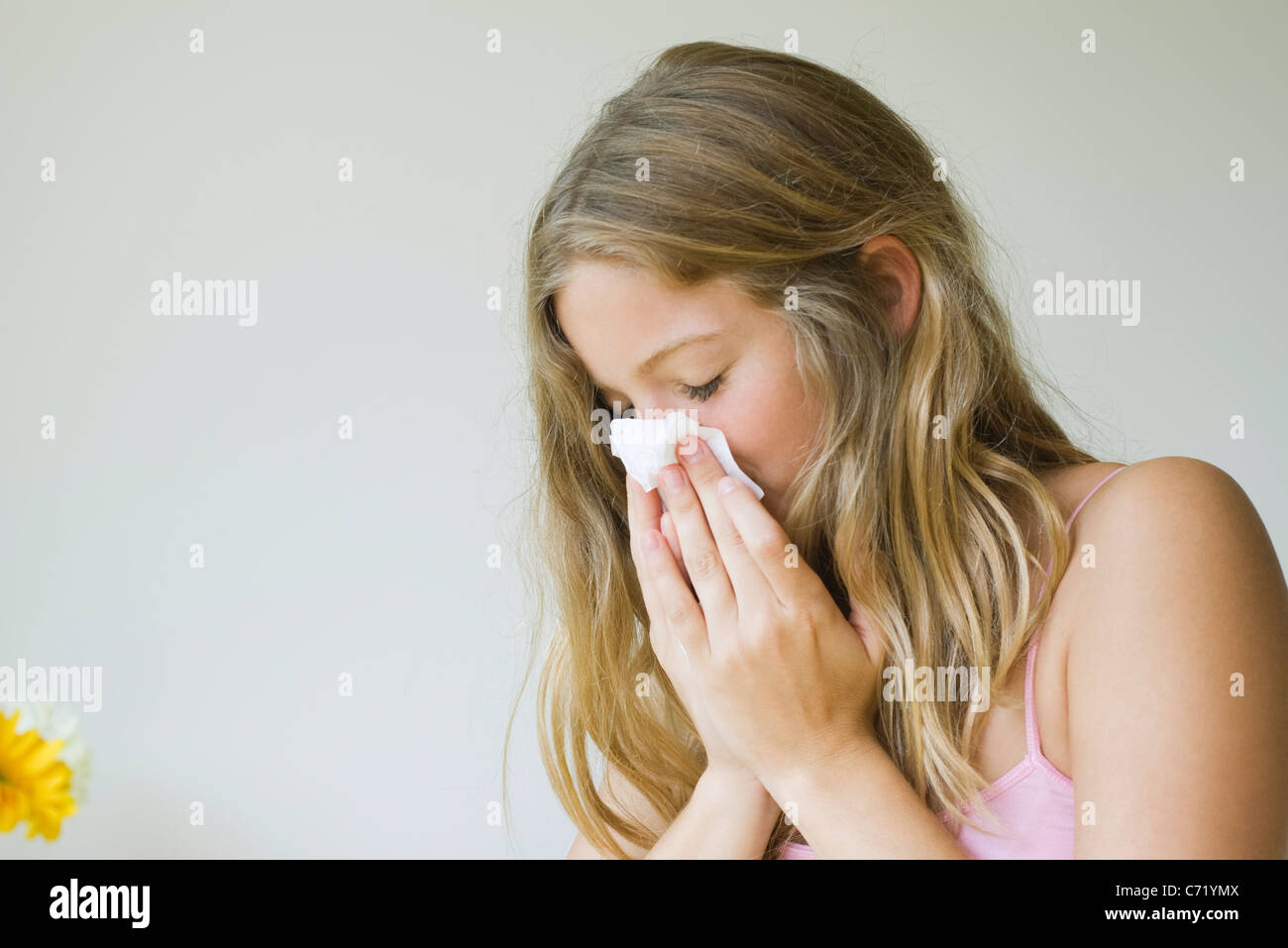Young woman blowing her nose Stock Photo - Alamy