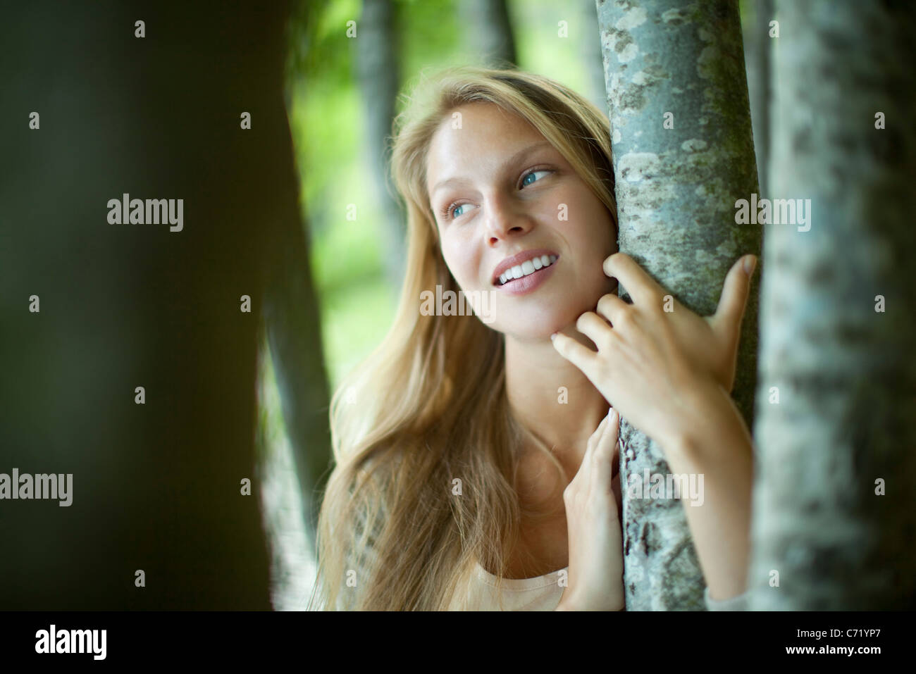 Young woman hugging tree Stock Photo - Alamy