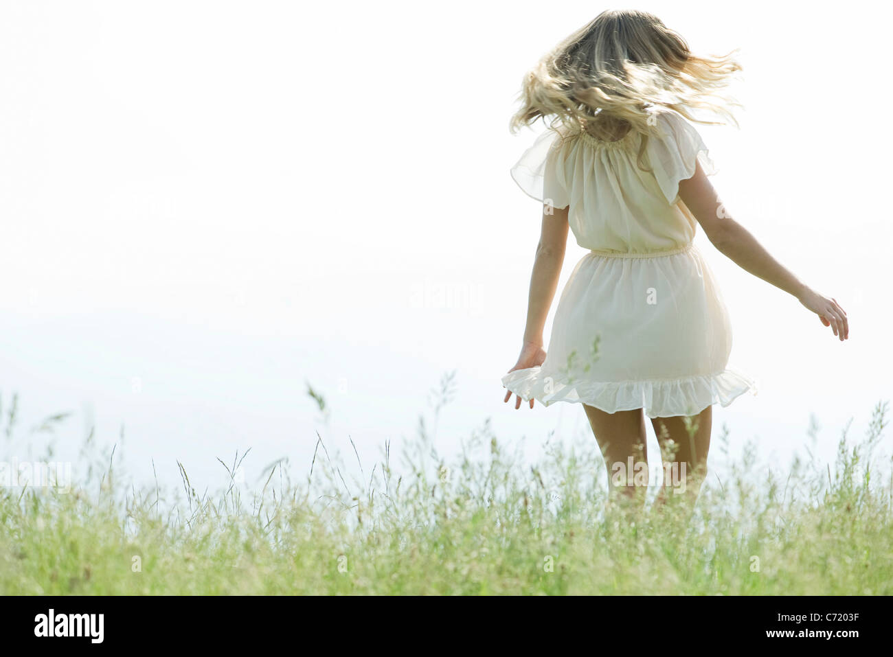 Young woman jumping in meadow, rear view Stock Photo - Alamy