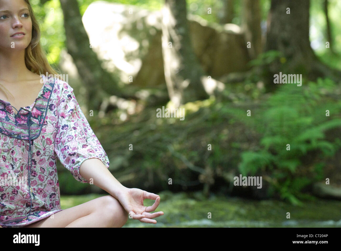 Young woman sitting in lotus position outdoors Stock Photo - Alamy