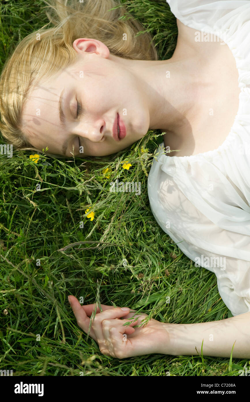 Young woman napping on grass Stock Photo - Alamy