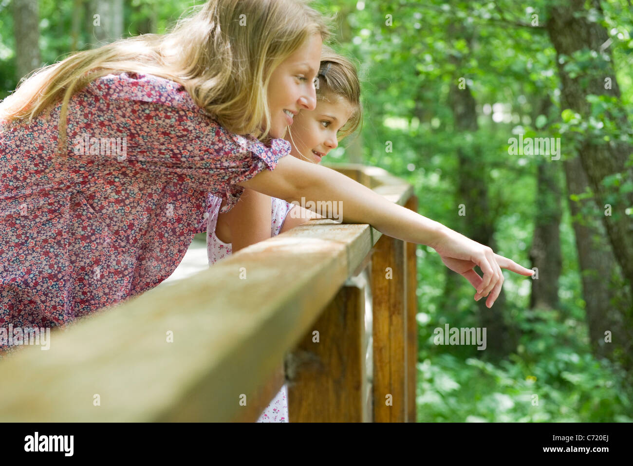 Mother and young daughter looking over railing together Stock Photo - Alamy