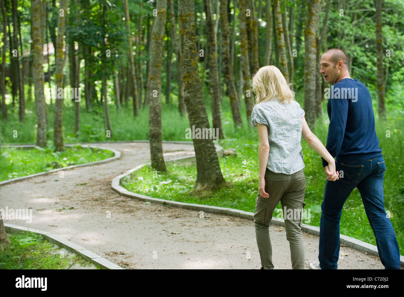 Couple walking on path in woods Stock Photo - Alamy