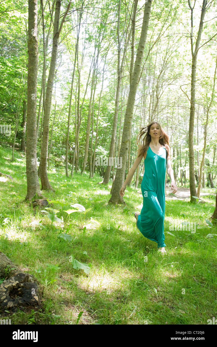 Young woman running through woods Stock Photo - Alamy