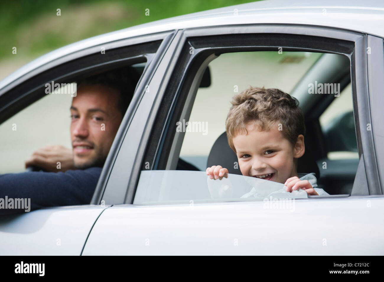 Father and son smiling out car window at camera Stock Photo - Alamy