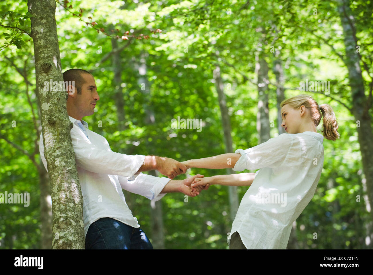 Couple holding hands and leaning back Stock Photo - Alamy