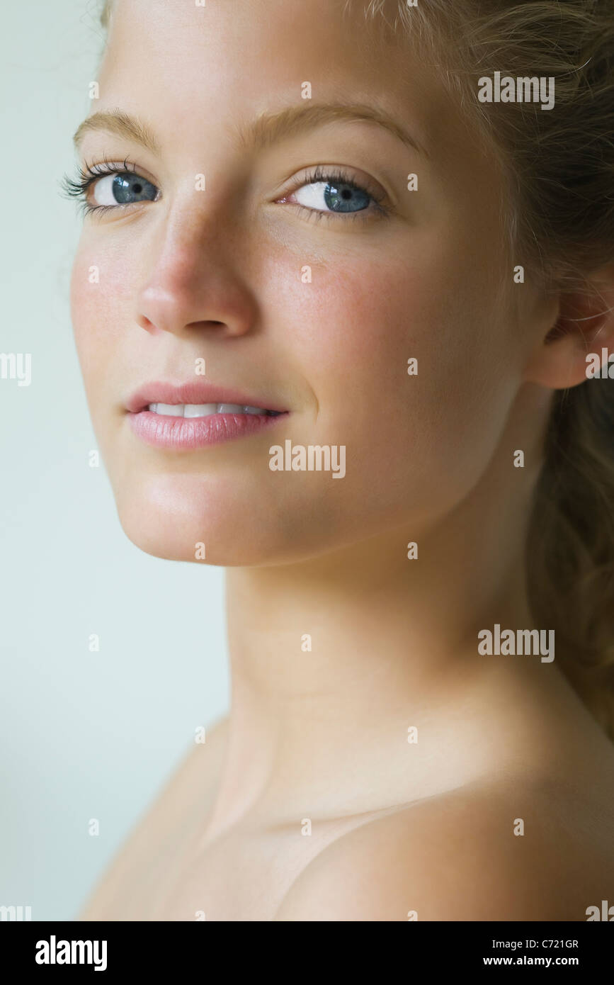 Young woman looking over shoulder at camera, portrait Stock Photo - Alamy