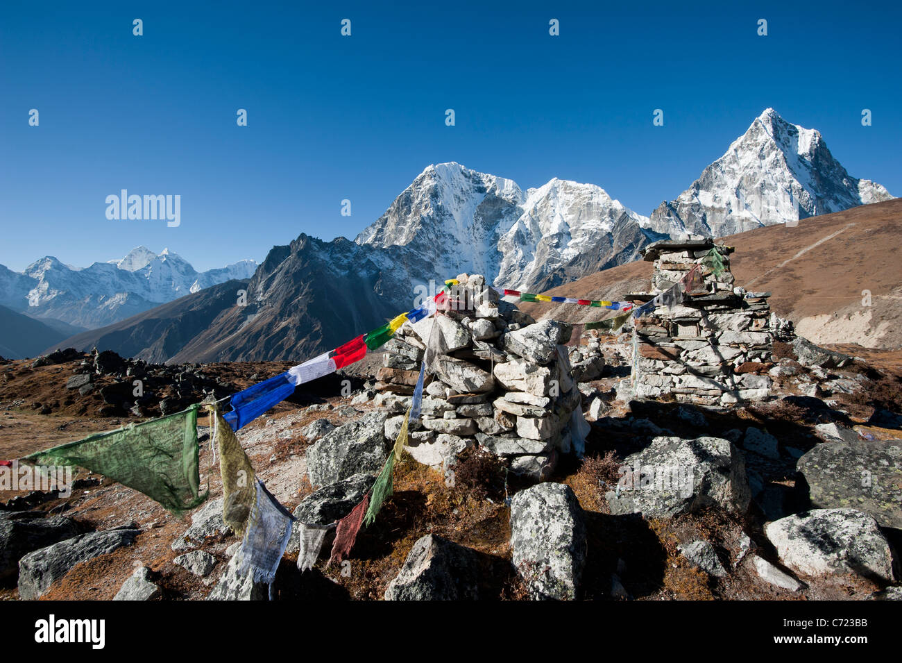 Stacked stones and prayer flags commemorate the fallen climbers and ...