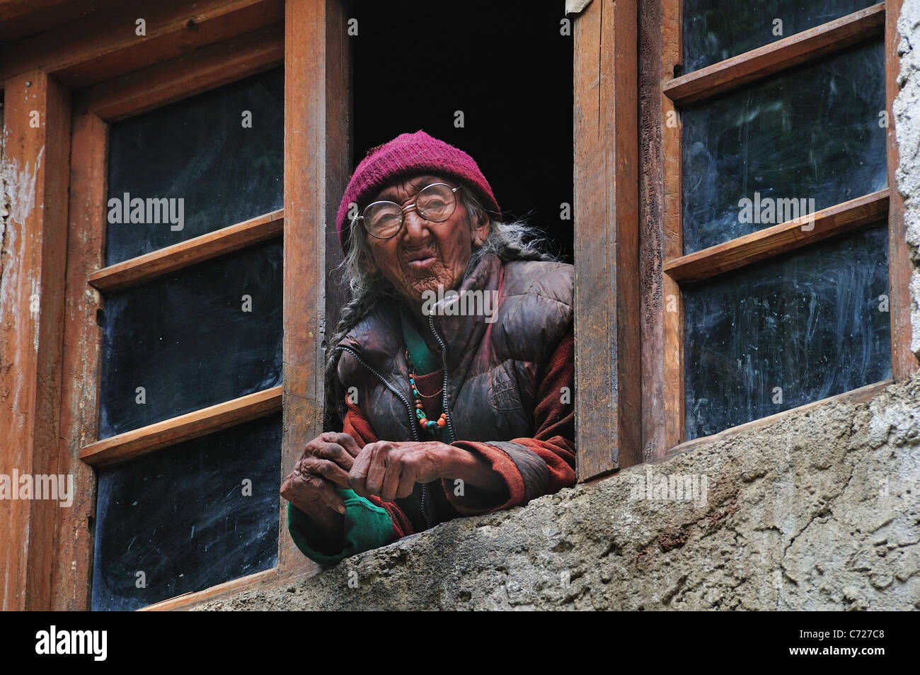 Woman looking out from her house window Stock Photo - Alamy