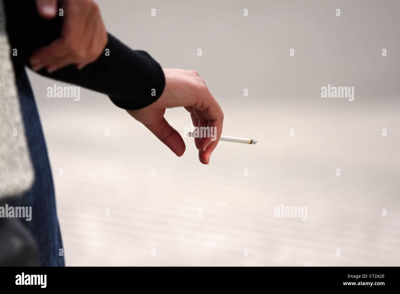 A hand holding a lighted cigarette Stock Photo - Alamy