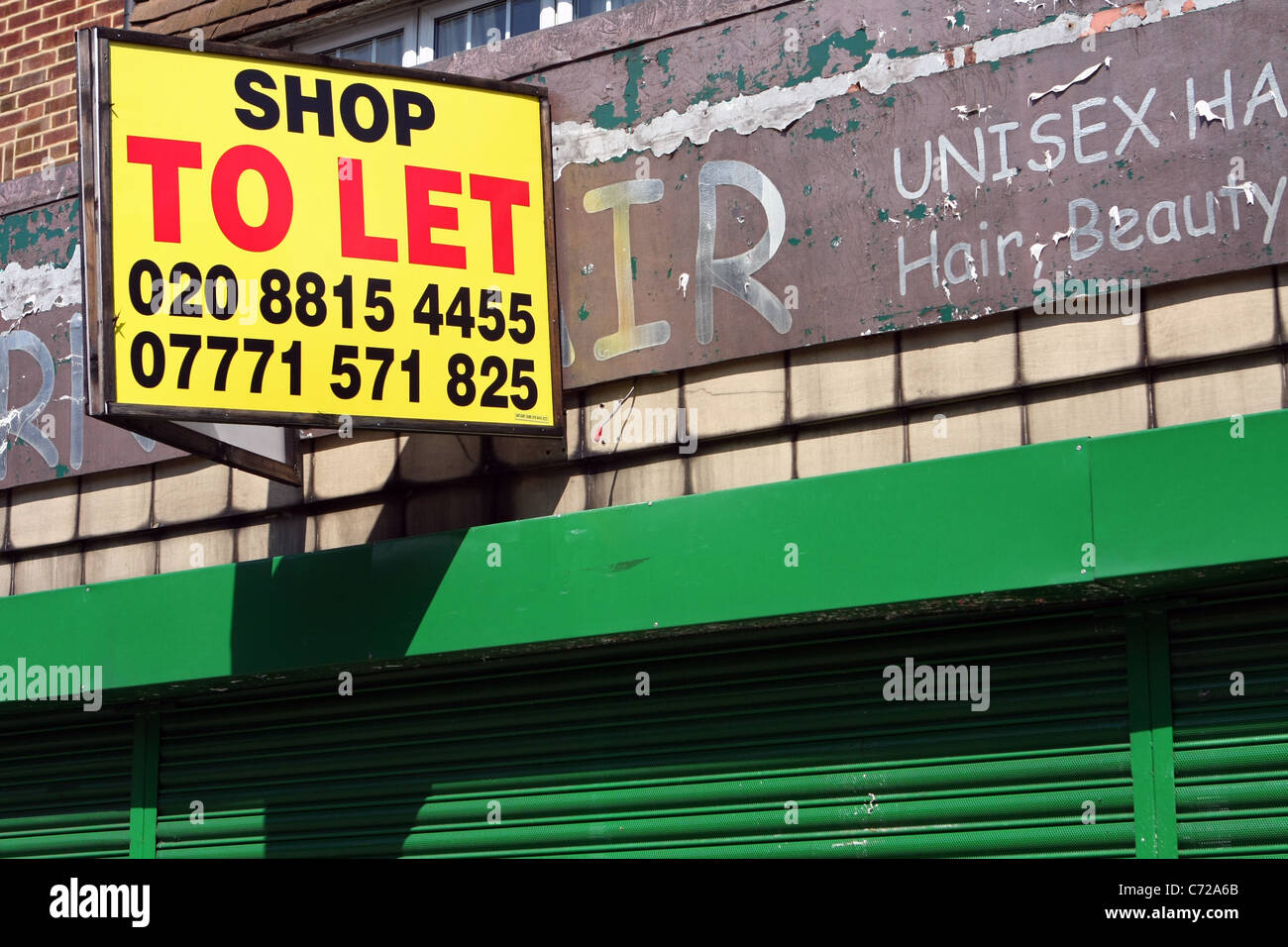 A 'Shop To Let' sign above an empty shop Stock Photo - Alamy