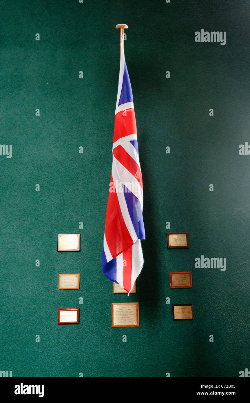 A Union Flag on a dark green wall with plaques remembering dead ...