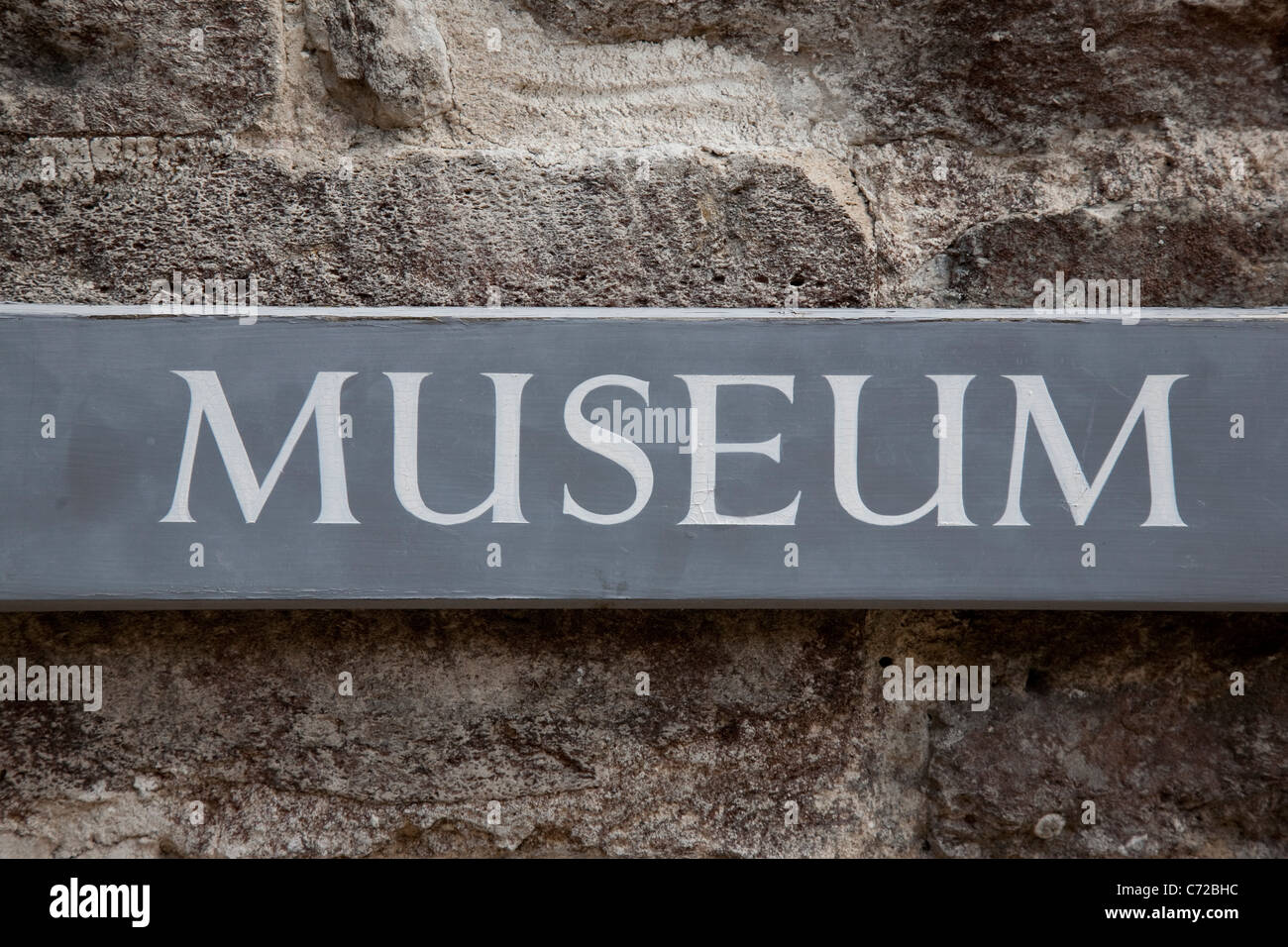 Grey Wooden Museum Sign on Stone Wall Stock Photo - Alamy