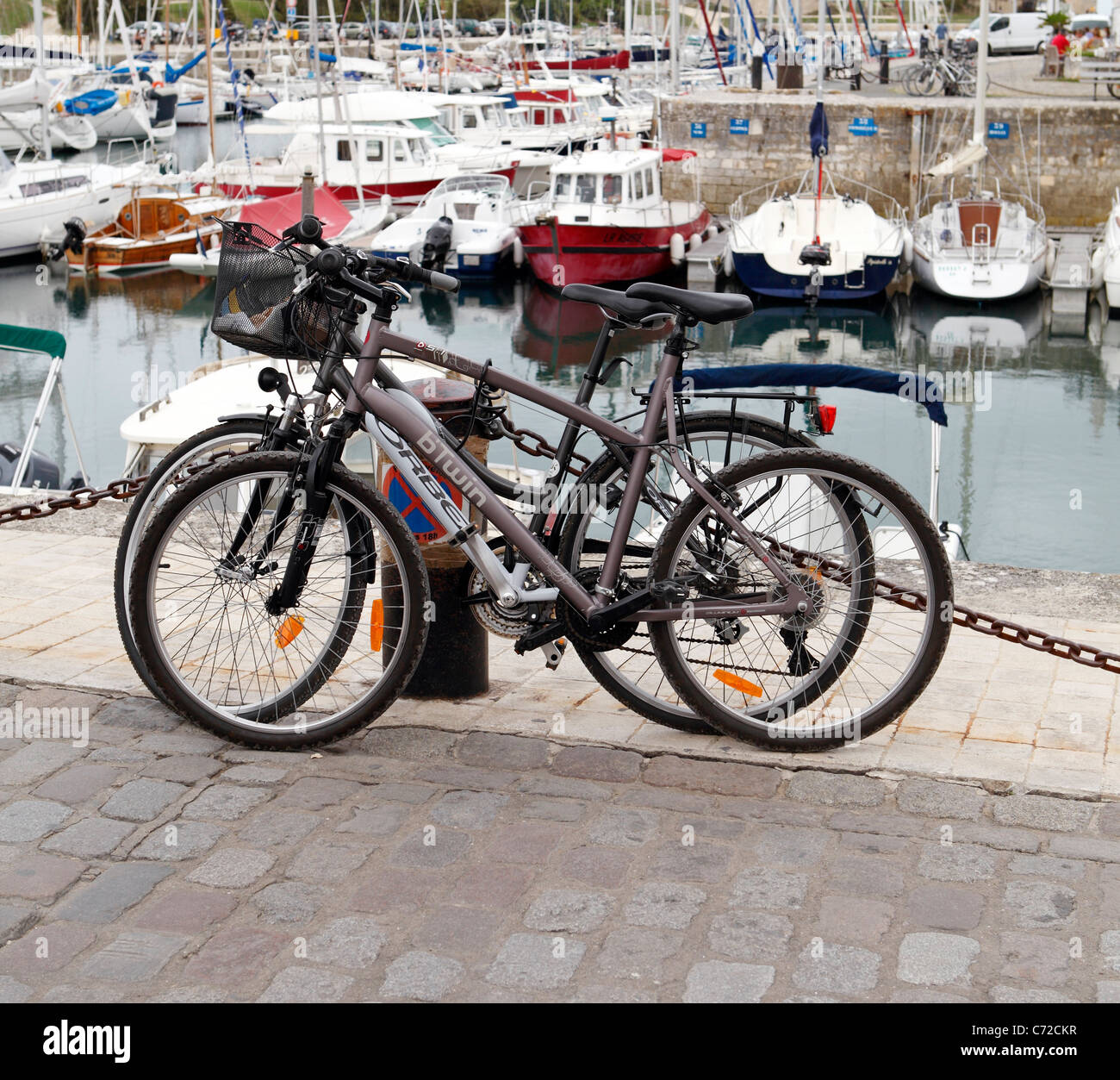 bikes resting up against a bollard at a french harbour in the vendee ...