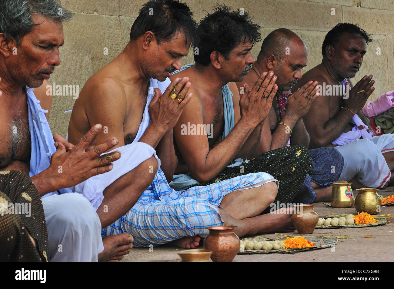 Pilgrims praying at the ghat by the Ganges river Stock Photo - Alamy