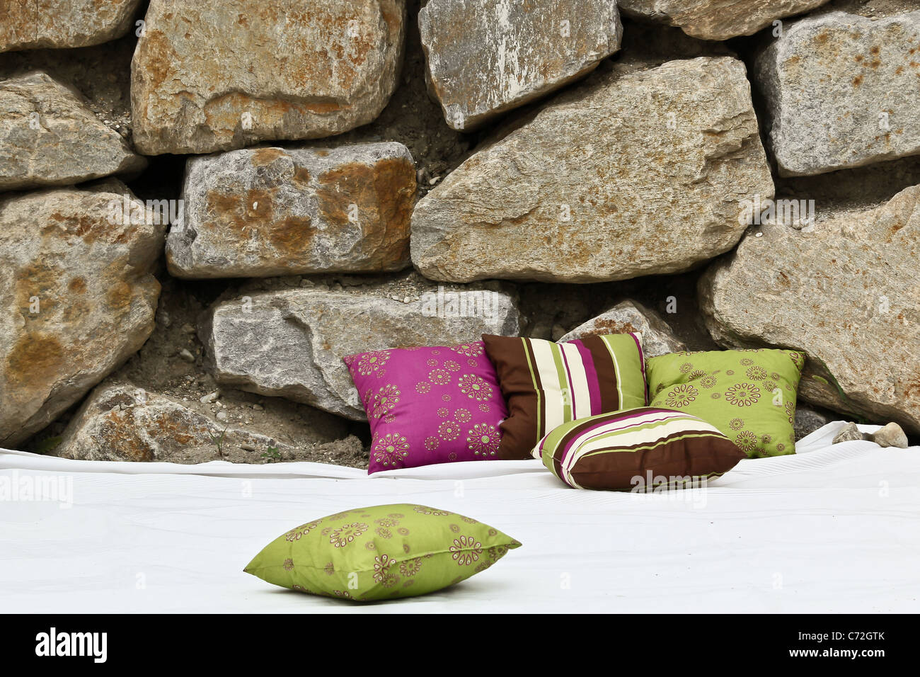 A resting place with pillows in front of a rock wall Stock Photo - Alamy