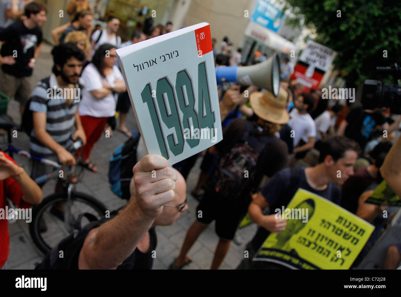 An Israeli demonstrator holds a copy of George Orwell's dystopian ...