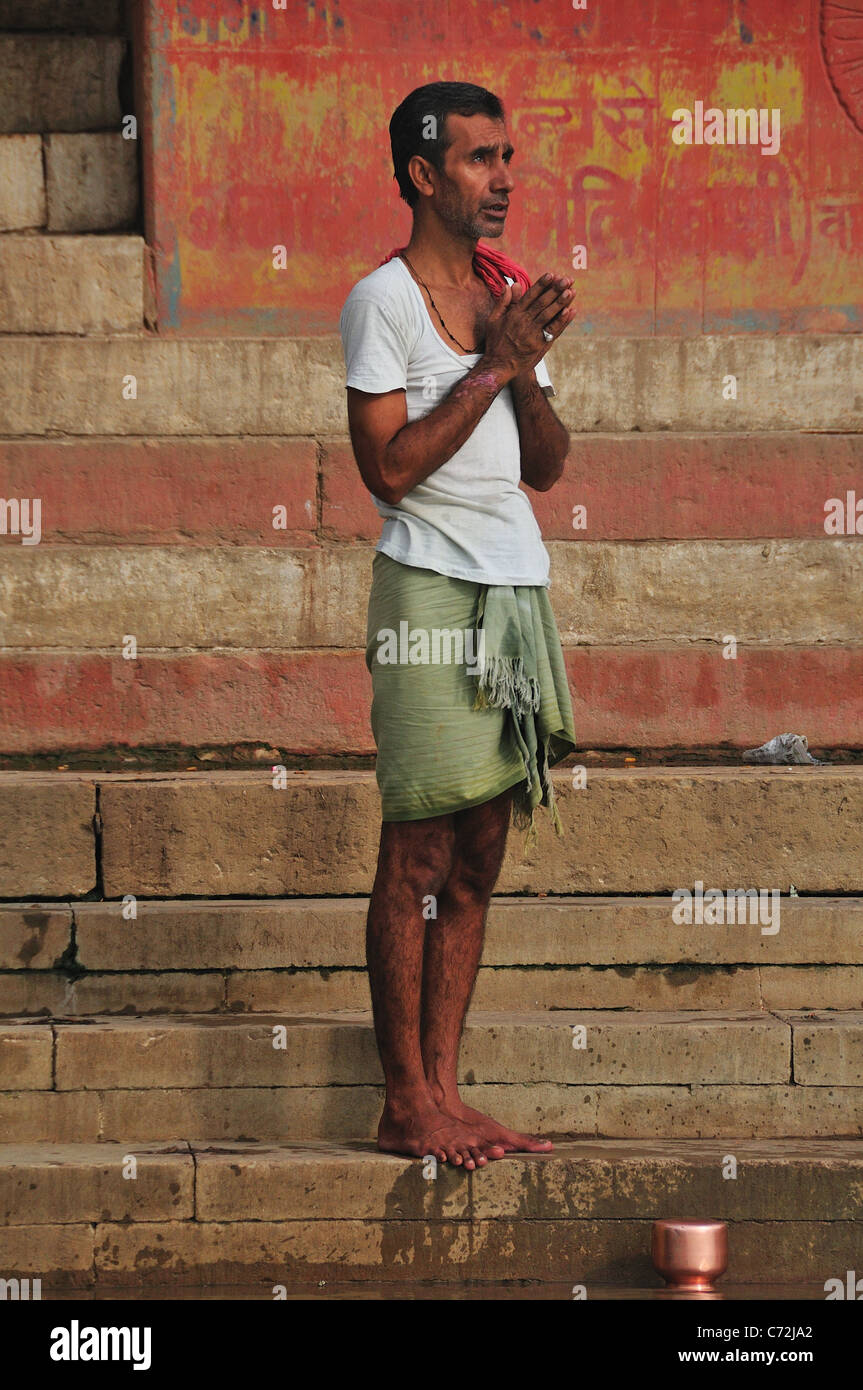 Pilgrims praying at the ghat by the Ganges river Stock Photo - Alamy